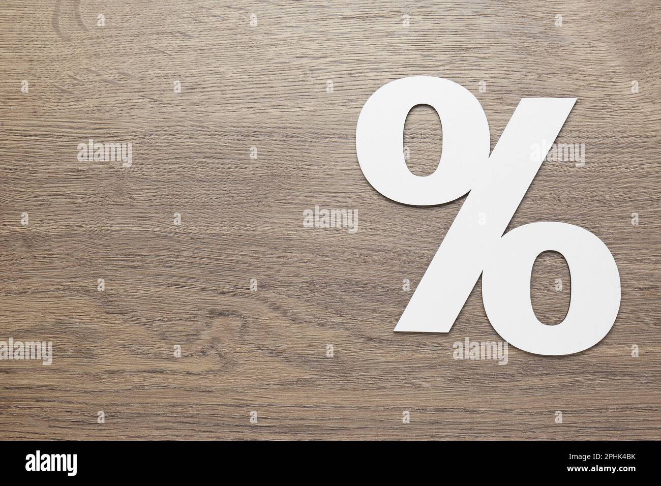 Paper percent symbol cutout on wooden background, top view. Space for ...