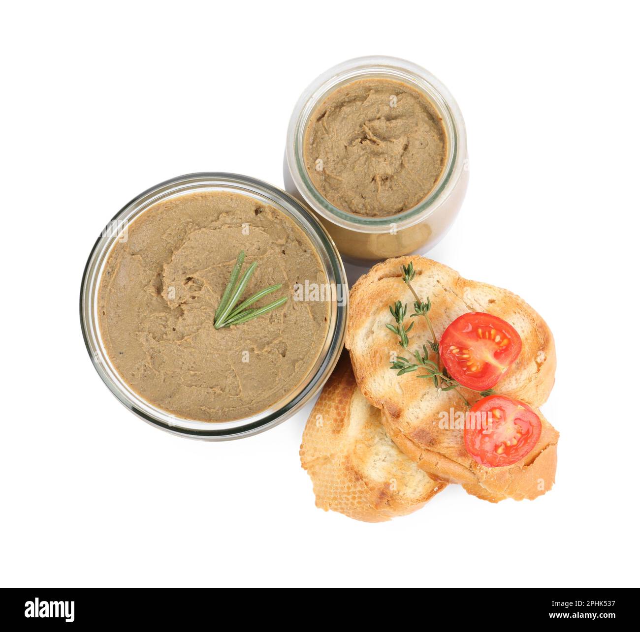 Glass jars with tasty liver pate, bread and tomato on white background ...