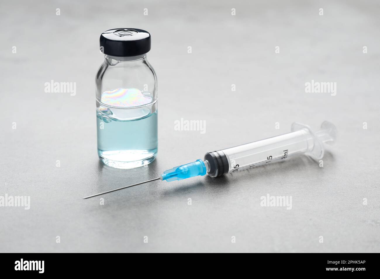 Syringe and vial on grey table. Medical anesthesia Stock Photo - Alamy