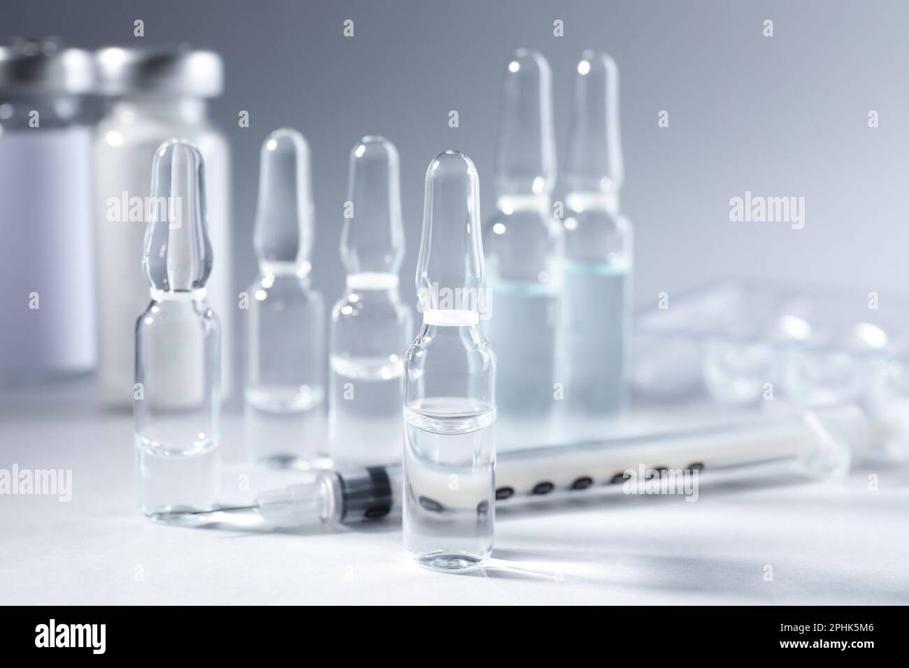 Pharmaceutical ampoules and syringe on light grey background Stock ...
