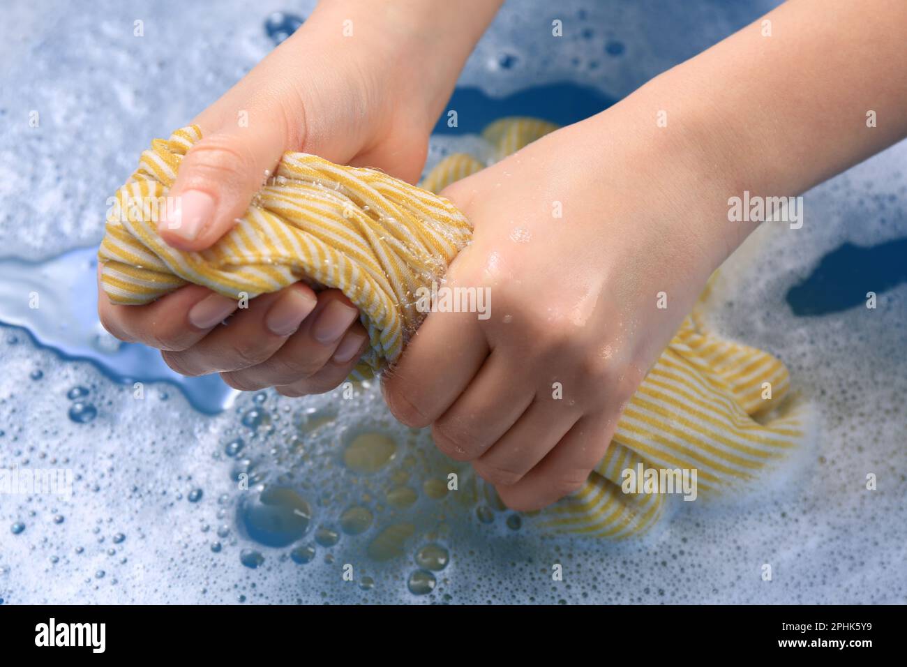Woman wringing garment over basin, closeup. Hand washing laundry Stock ...
