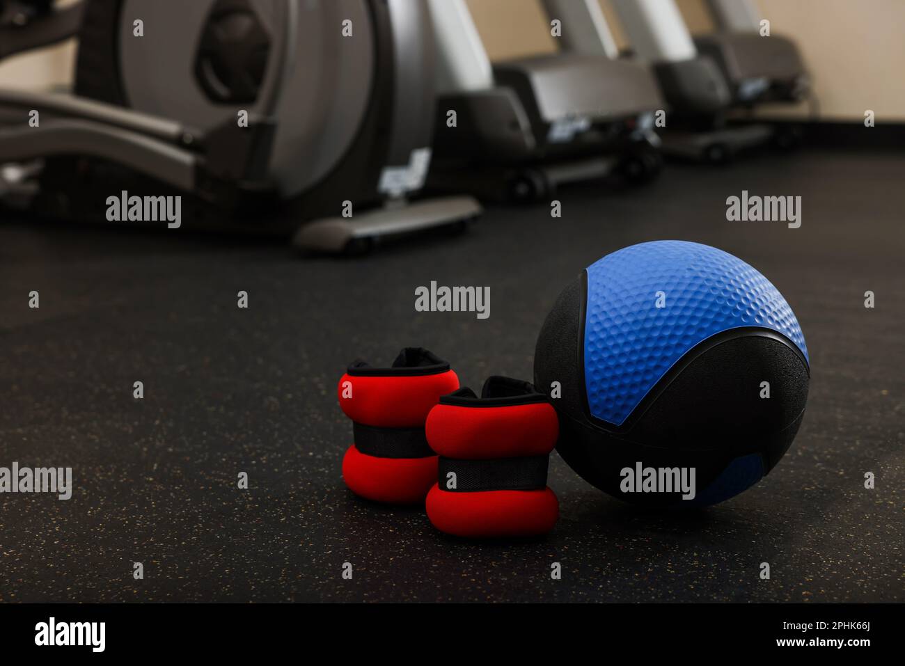 Blue medicine ball and ankle weights on floor in gym, space for text ...