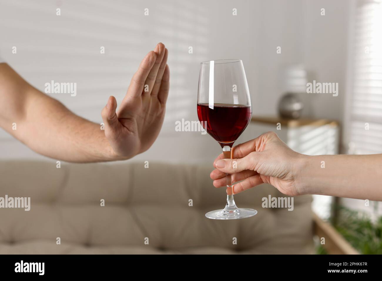 Man refusing to drink red wine indoors, closeup. Alcohol addiction ...