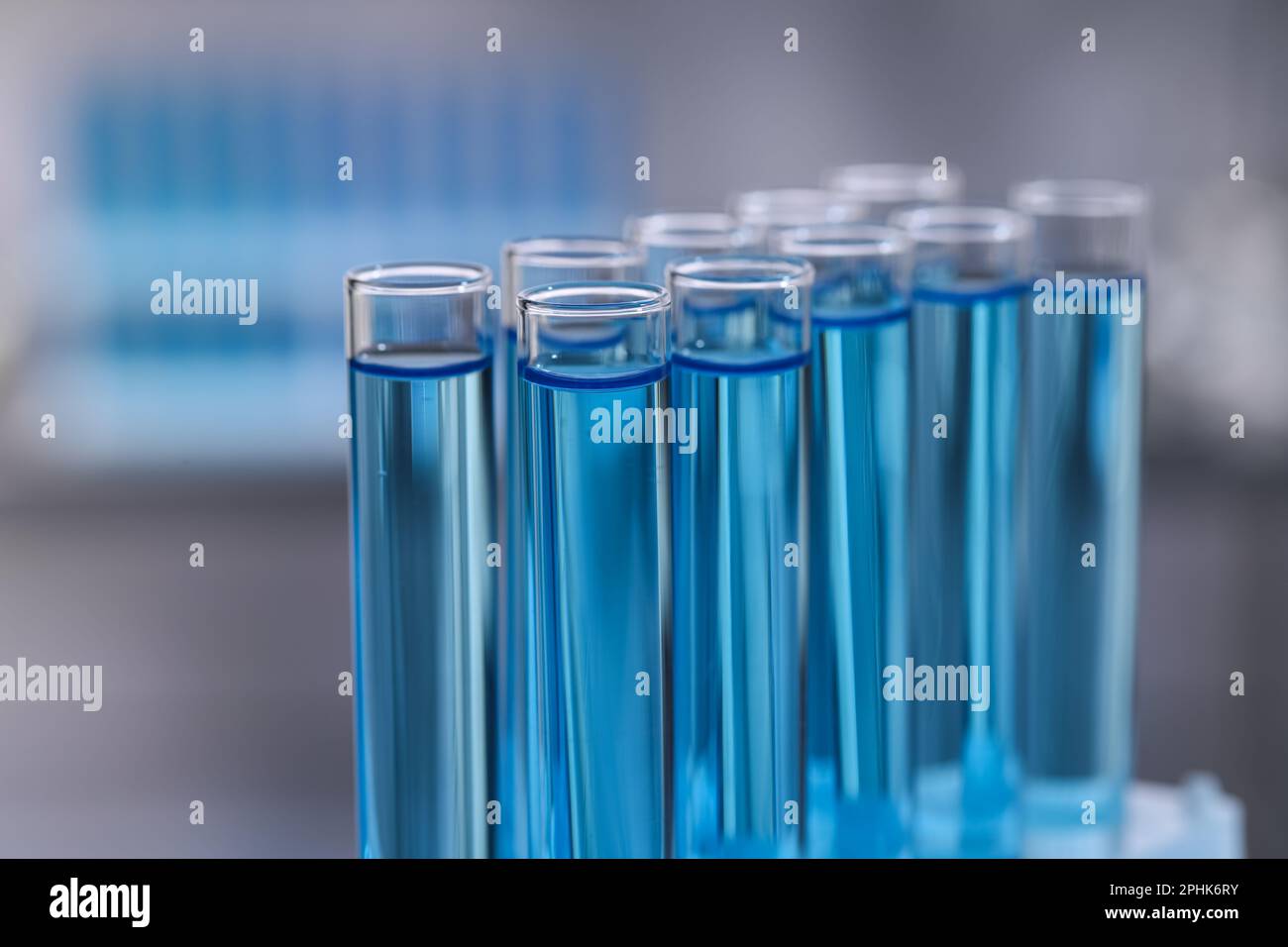 Test tubes with reagents on blurred background, closeup. Laboratory ...