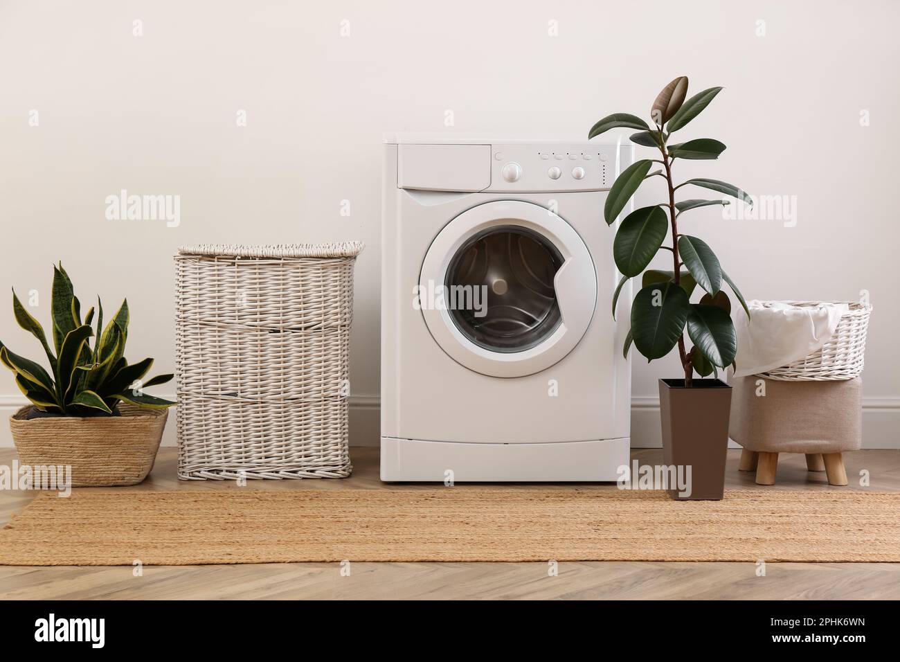 Laundry room interior with modern washing machine and wicker basket ...