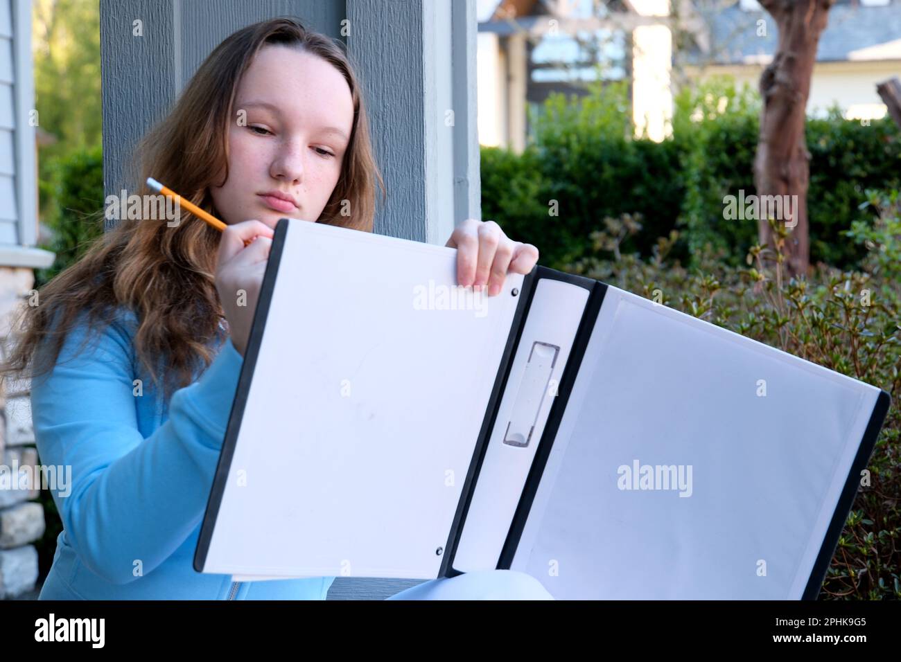 drawing lesson teenage girl draws in a large notebook in a folder with ...