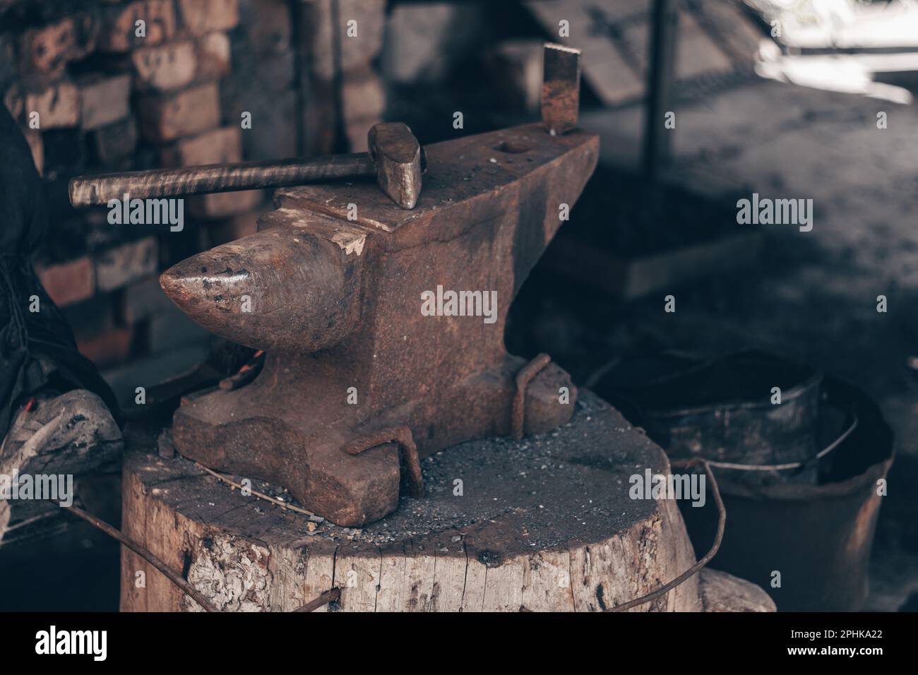 Process metal with hammer on anvil in forge. Strike iron outdoors in ...