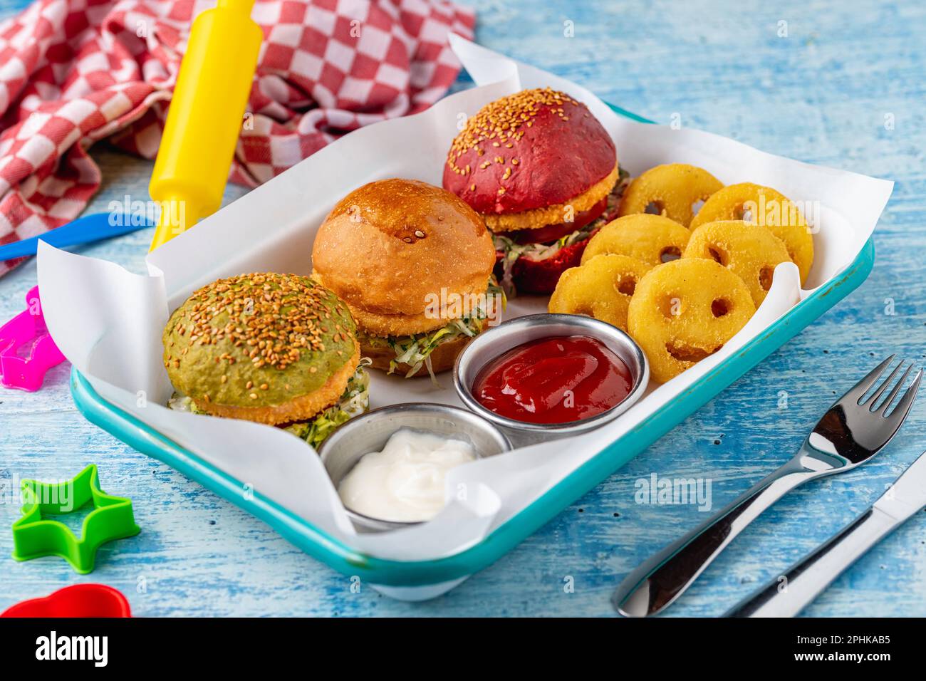three mini burgers with chicken and meat served with french fries. kids ...