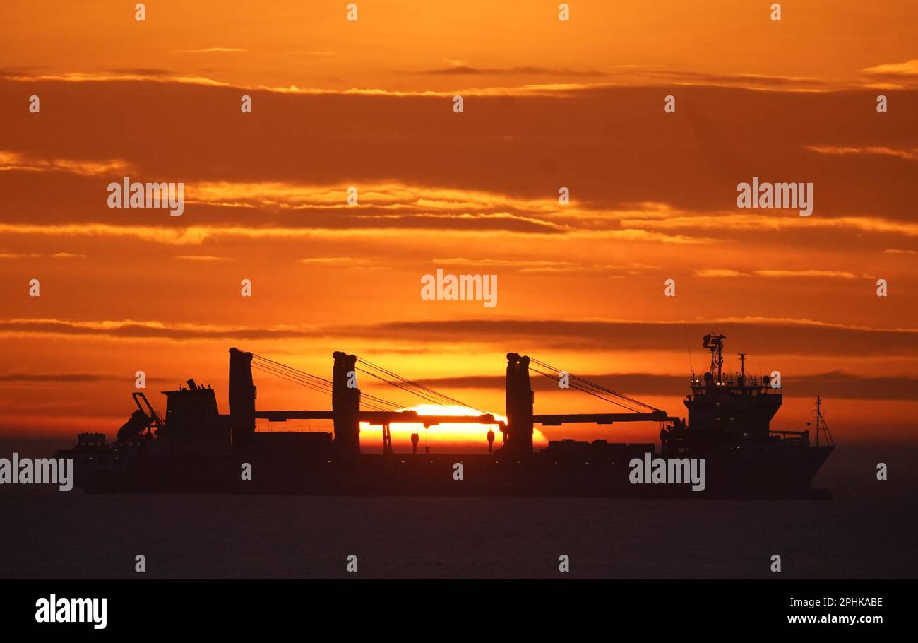 The cargo ship 'Maria' sits on the horizon as the sun rises over Brown ...