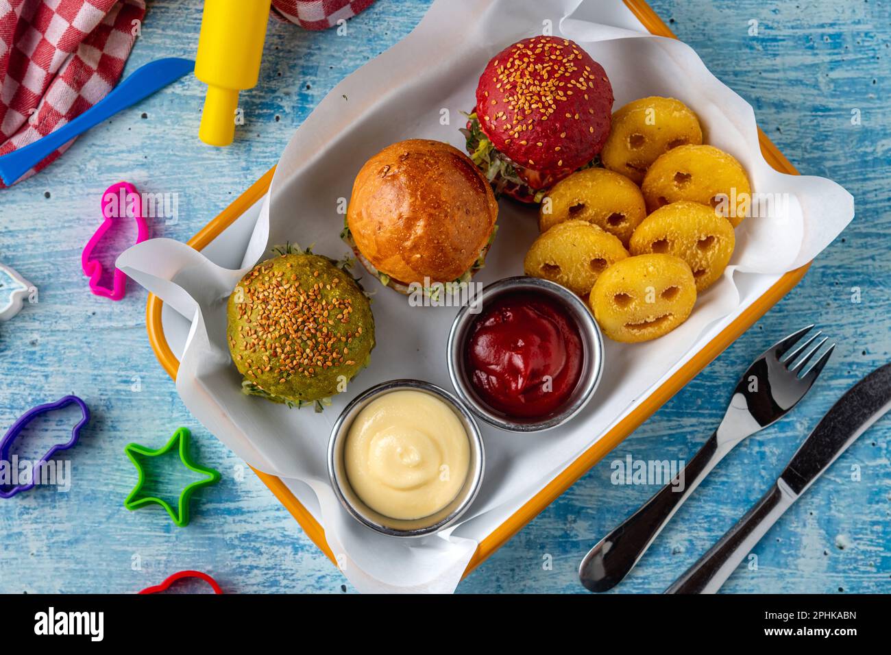 three mini burgers with chicken and meat served with french fries. kids ...