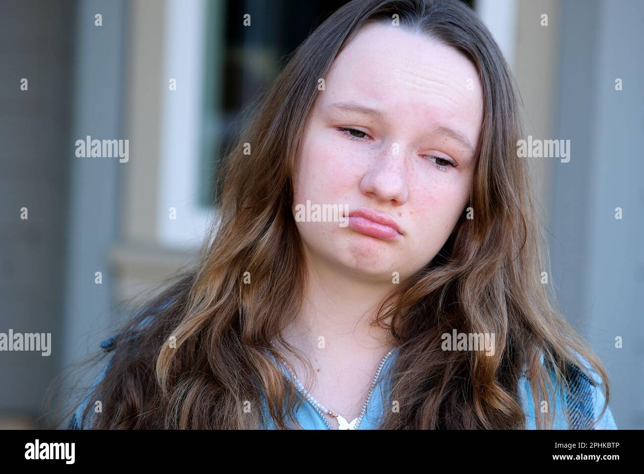 Side view young woman looking away at window sitting on couch at home ...