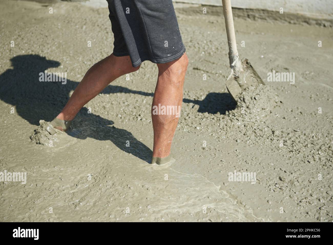 Builder in a concrete mortar, heavy construction work Stock Photo - Alamy