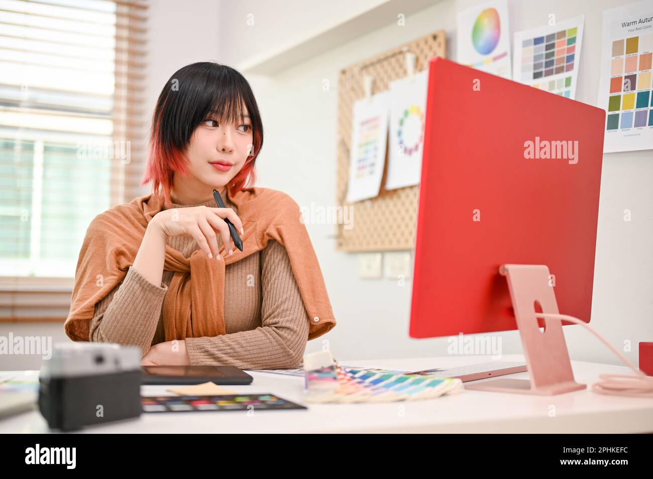 Focused and talented young Asian female graphic designer or editor ...