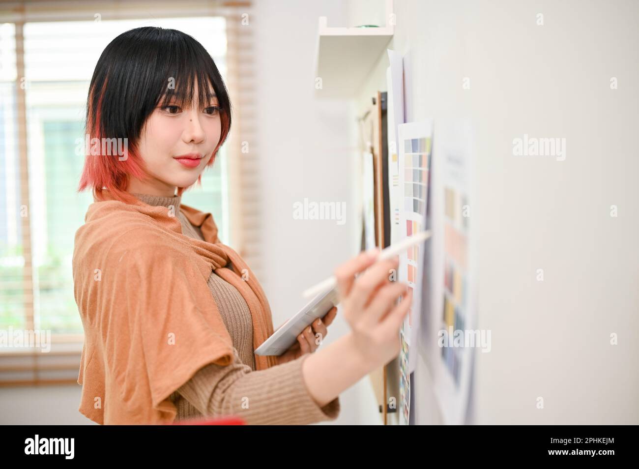 Inspired and talented young Asian female graphic designer working on ...