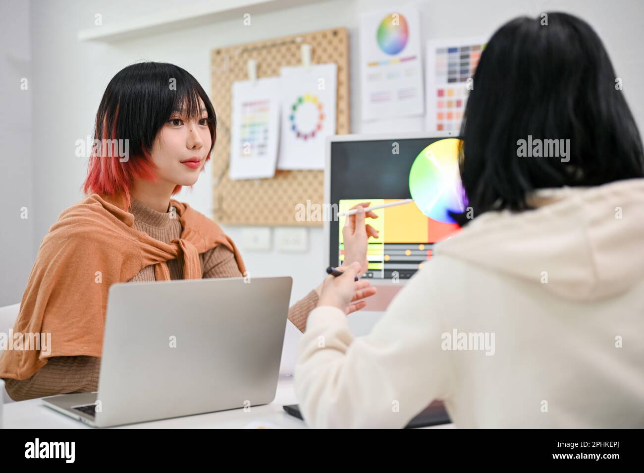 Focused and talented young Asian female graphic designer planning a new ...