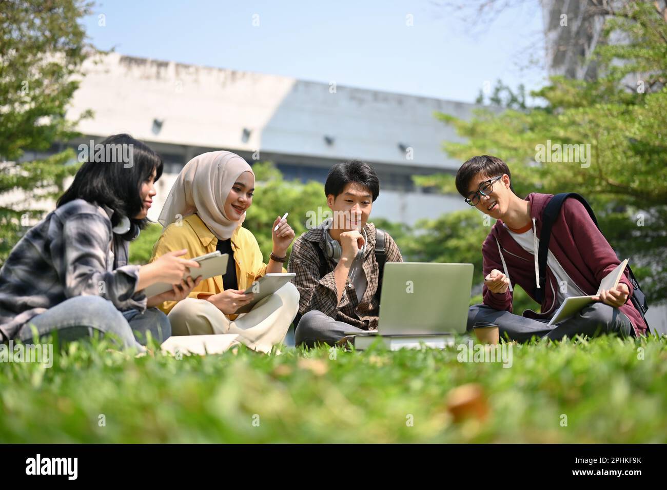 A group of happy and smart young Asian-diverse college students are talking and brainstorming on ...