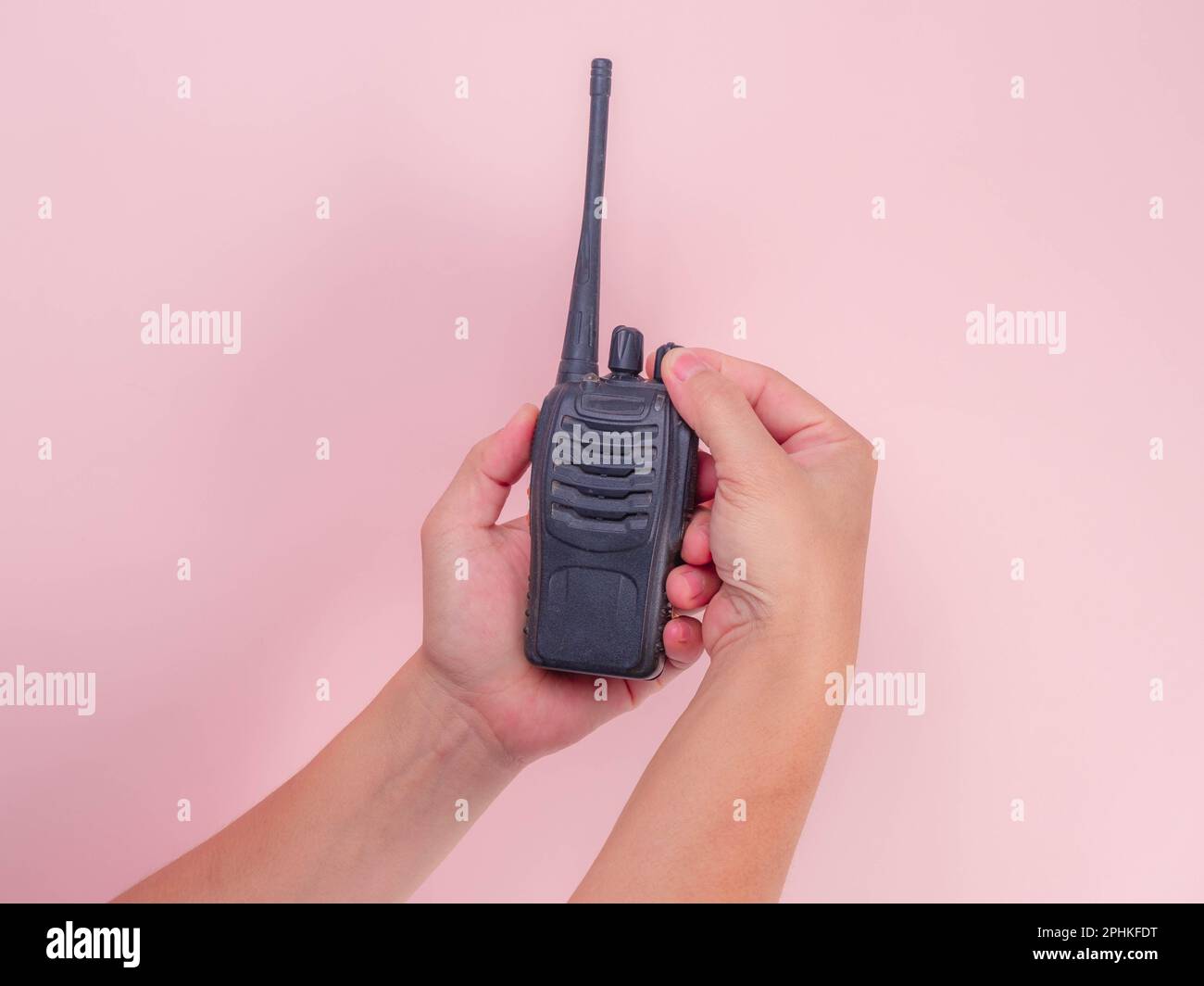 Close up hand holding portable walkie talkie isolated on pink ...