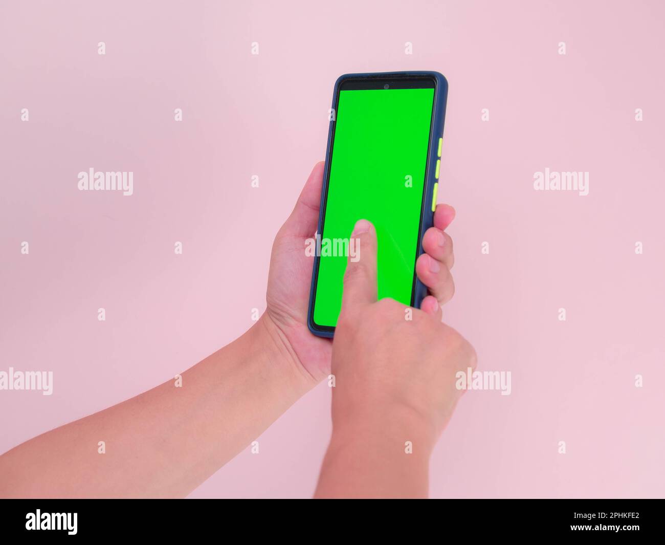 Human hand using mobile smartphone with green screen isolated on pink background. Woman hand ...