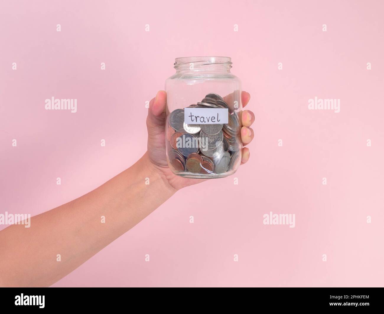 Close-up of young woman's hand holding glass jar with money (coin ...