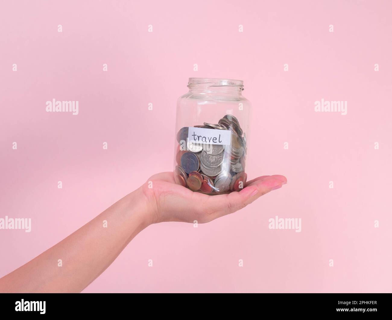 Close-up of young woman's hand holding glass jar with money (coin ...