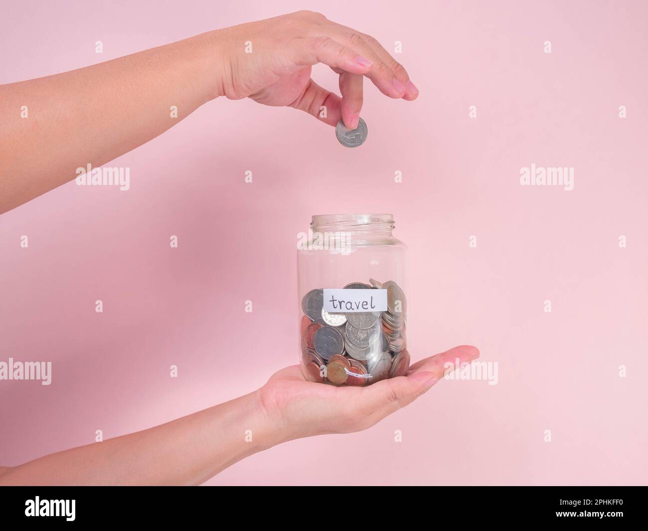 Close-up of young woman's hand holding glass jar with money (coin ...
