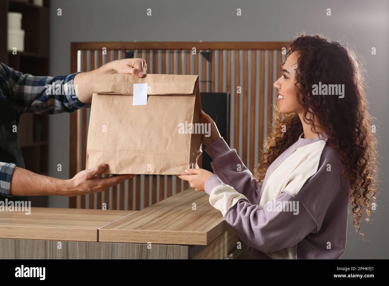 Worker giving paper bag to customer in cafe Stock Photo - Alamy
