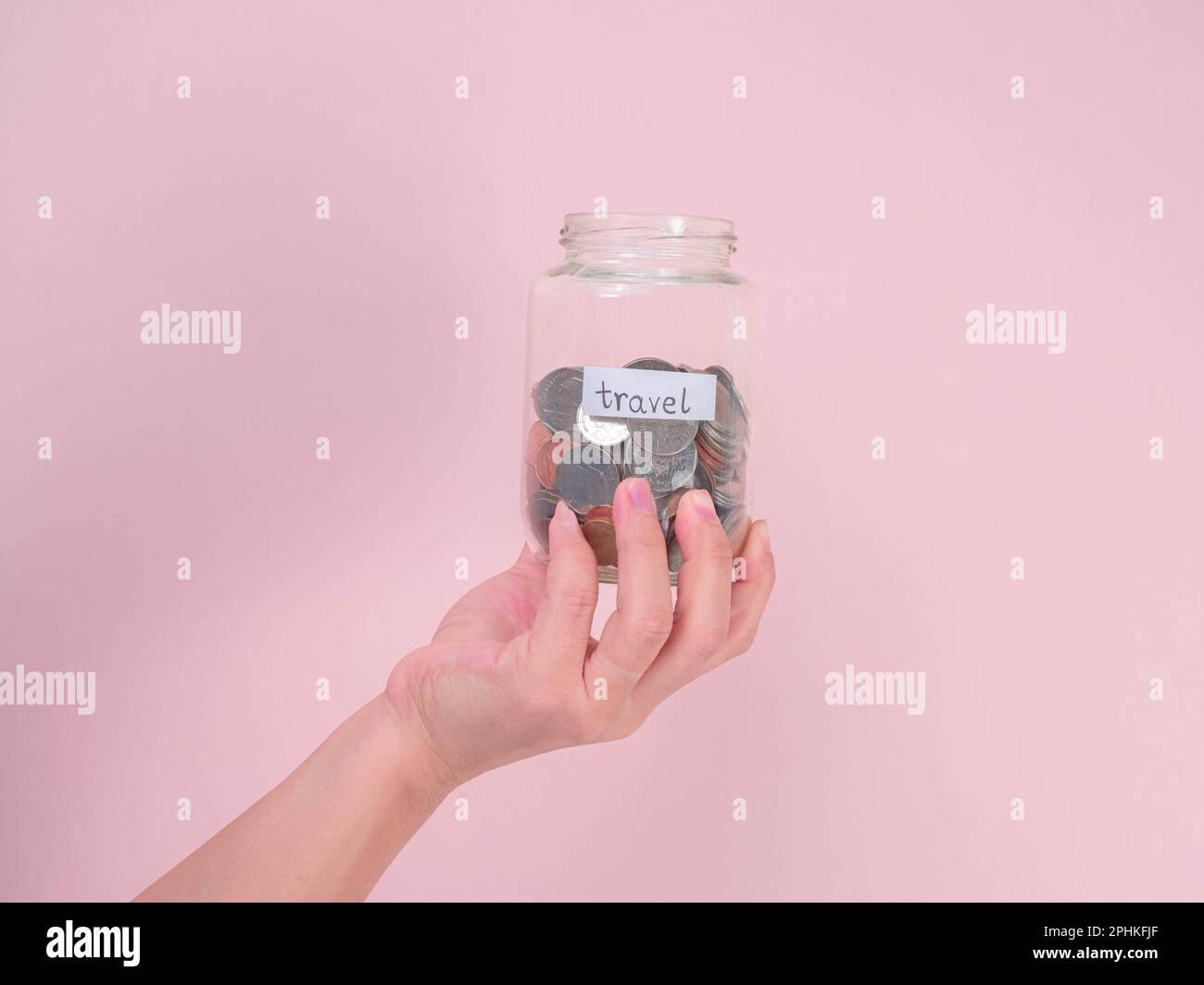 Close-up of young woman's hand holding glass jar with money (coin ...