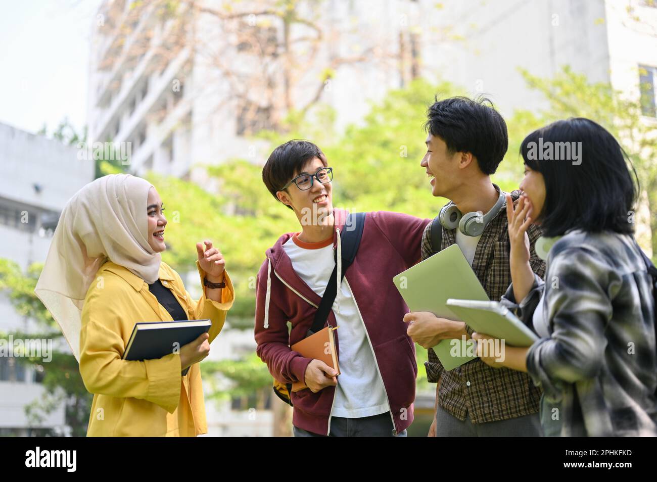 A group of joyful and happy young Asian-diverse college students are ...