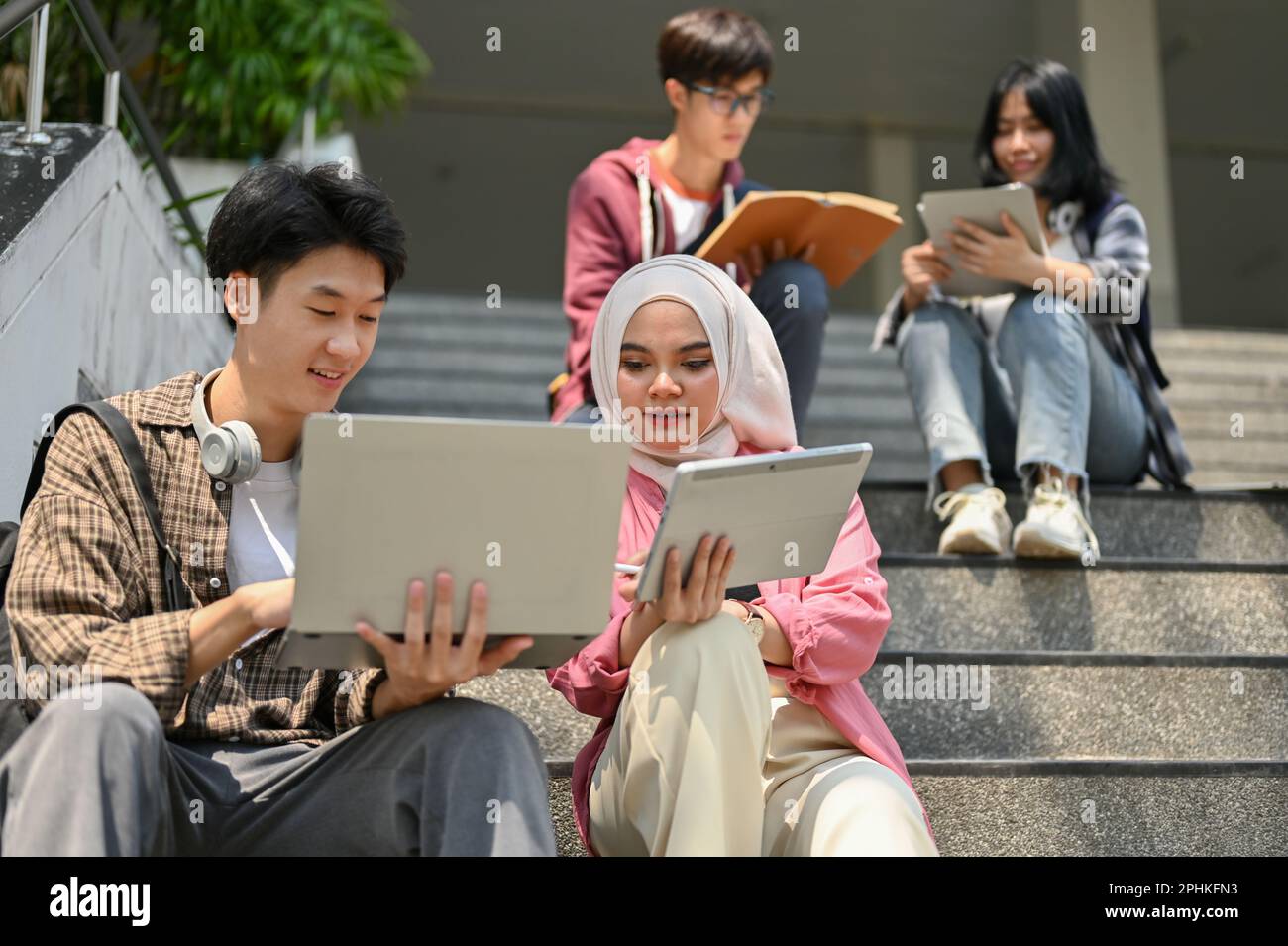 Attractive young Asian Muslim female college student focusing on ...