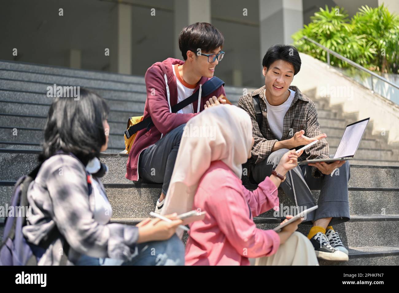 A group of Asian-diverse college students are talking, relaxing and ...