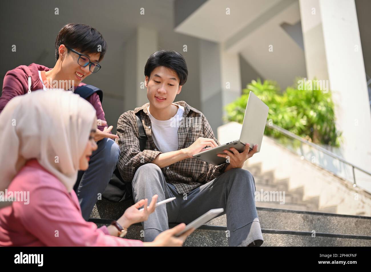 A group of Asian-diverse college students are talking, relaxing and ...