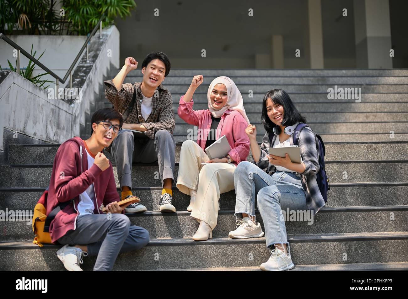 A group of Asian-diverse college students rejoicing and celebrating ...