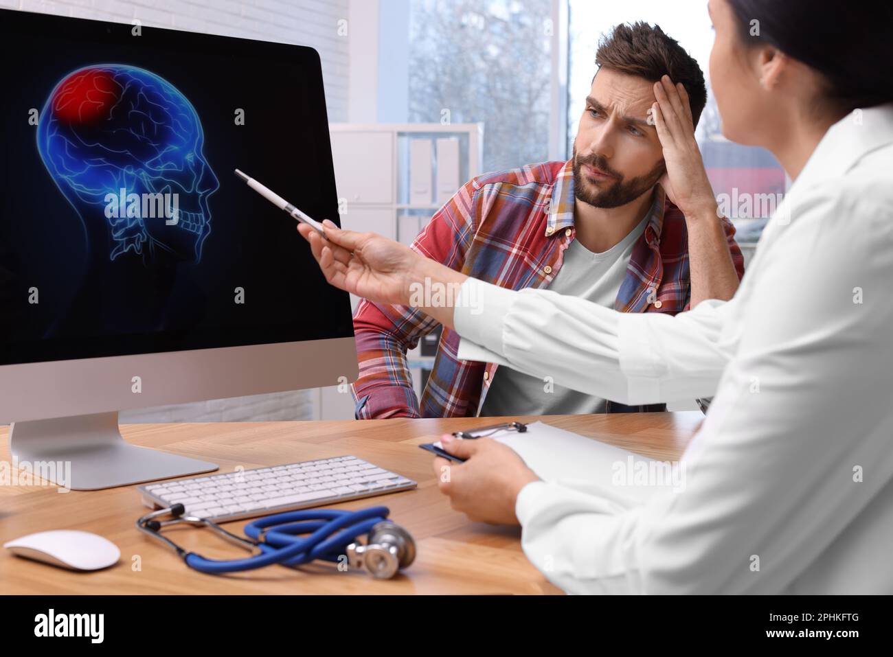 Neurologist showing brain scan to sad man in clinic Stock Photo - Alamy