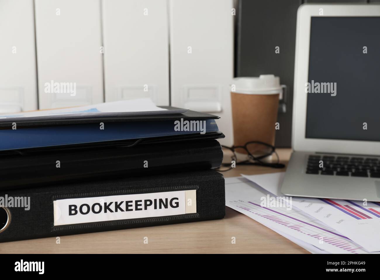 Folders, laptop and documents on desk in office. Bookkeeper's workplace ...