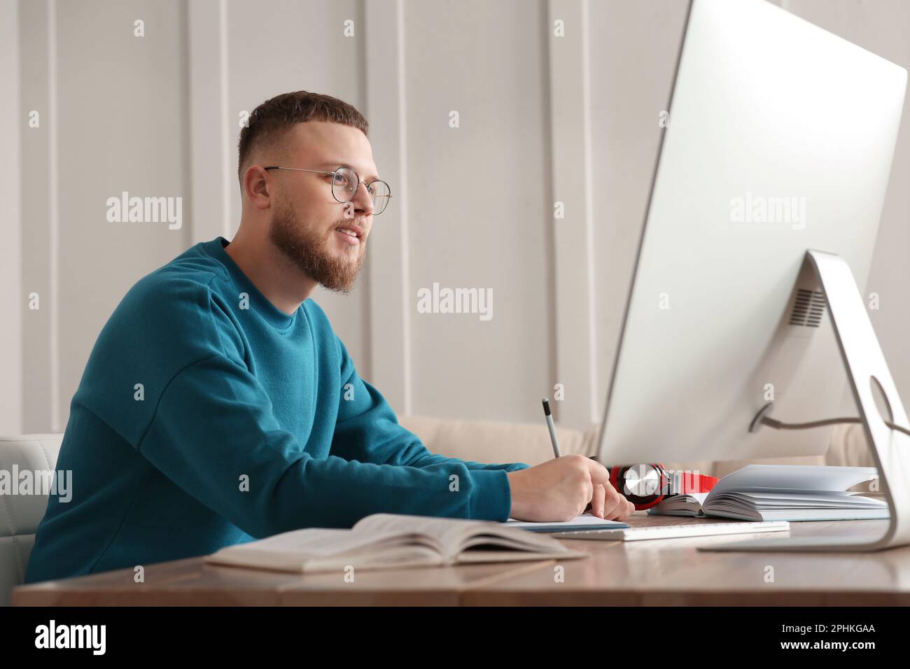 Online test. Man studying with computer at home Stock Photo - Alamy