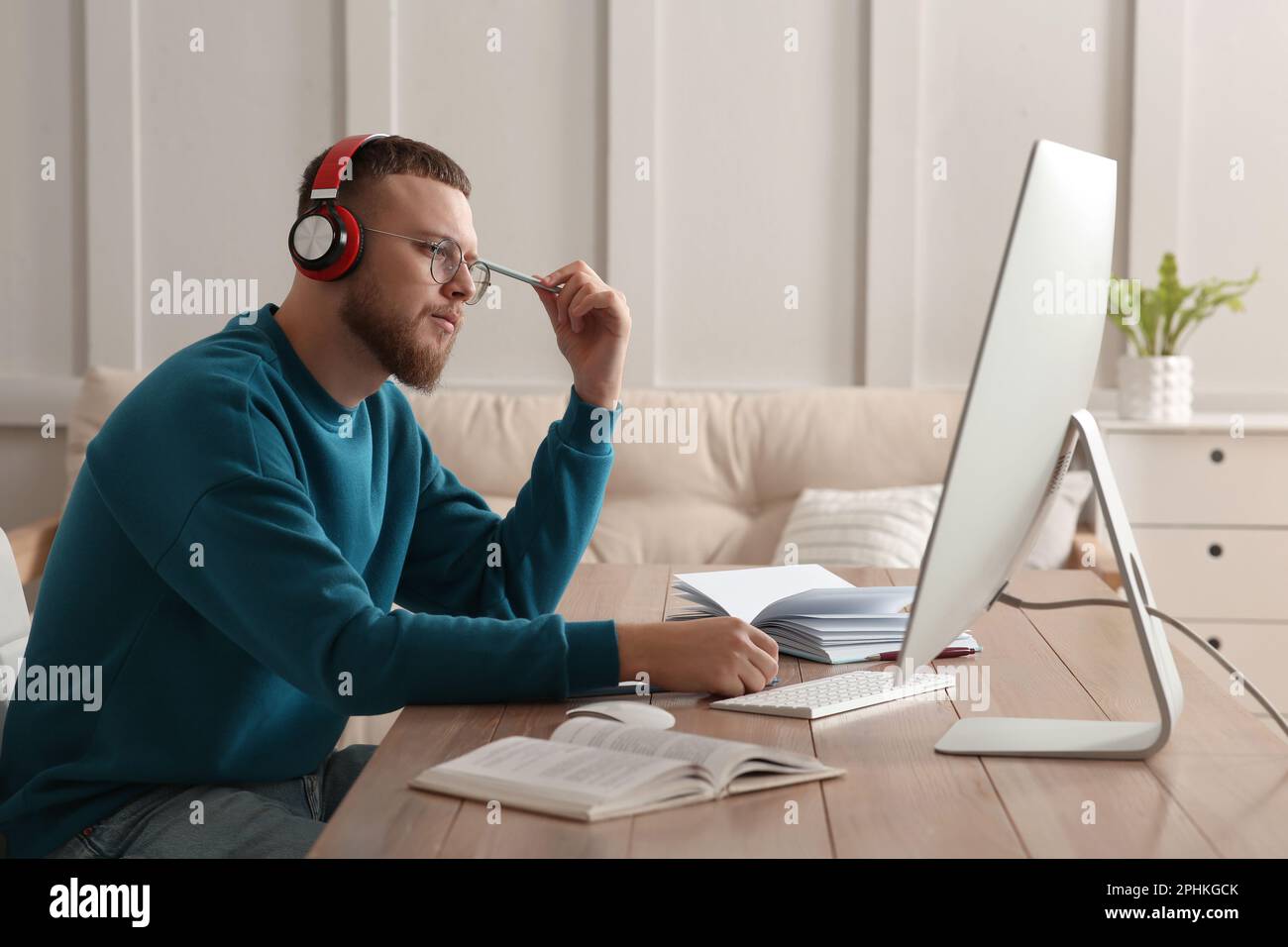 Online test. Man studying with computer at home Stock Photo - Alamy