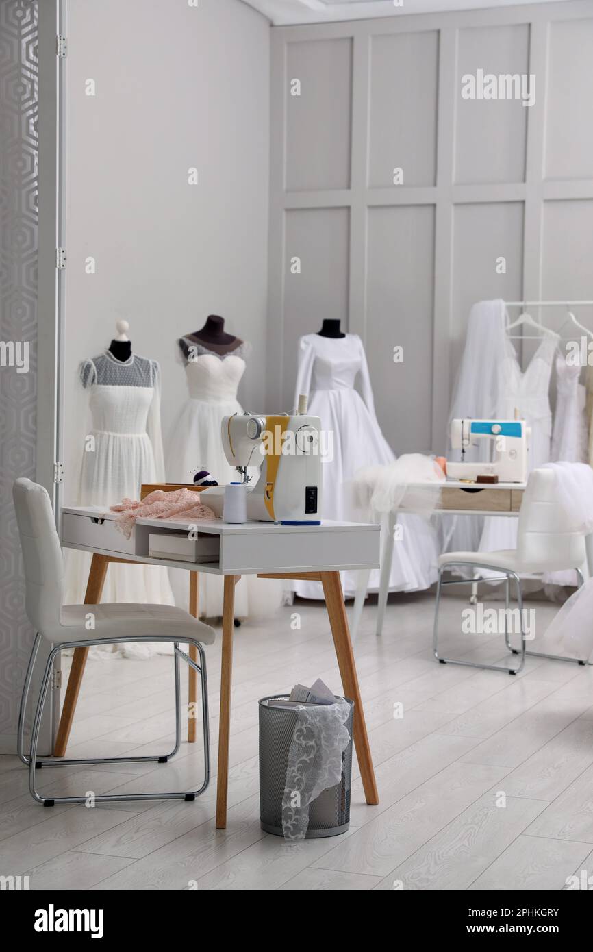 Dressmaking workshop interior with wedding dresses and equipment Stock ...