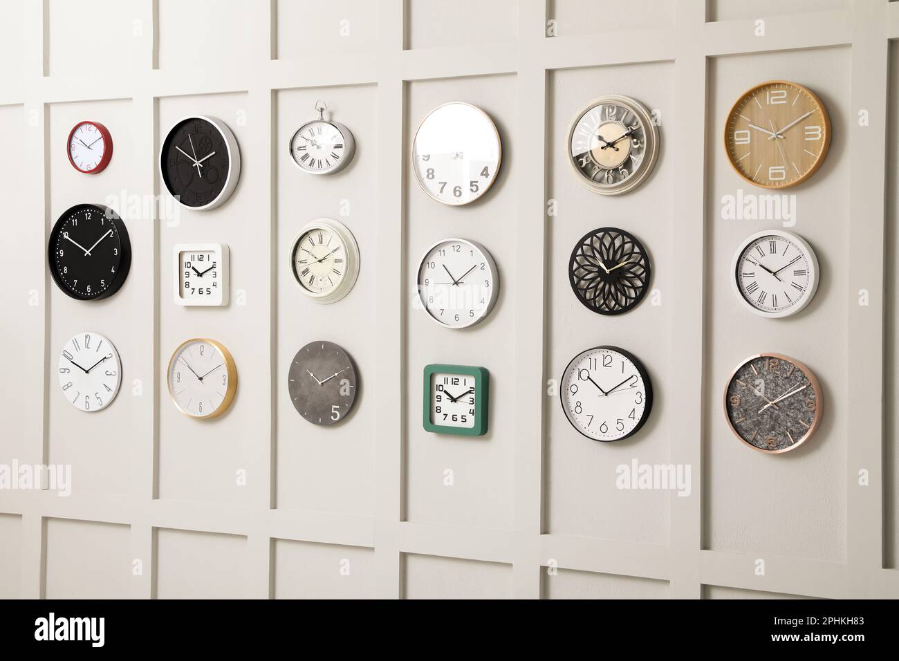 Many different clocks hanging on white wall Stock Photo - Alamy