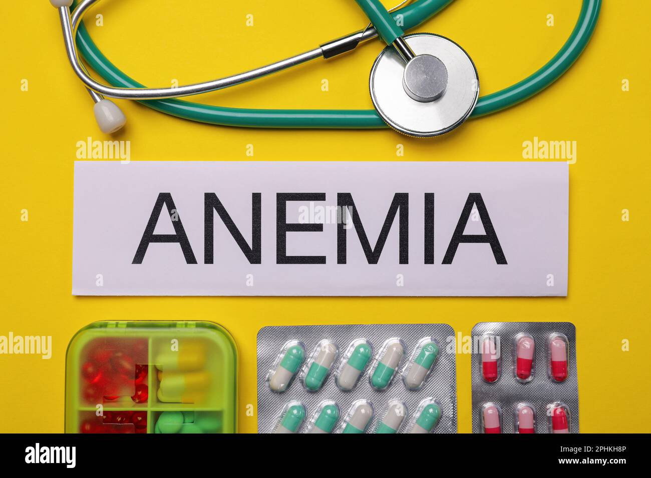 Card with word Anemia, different pills and stethoscope on yellow ...