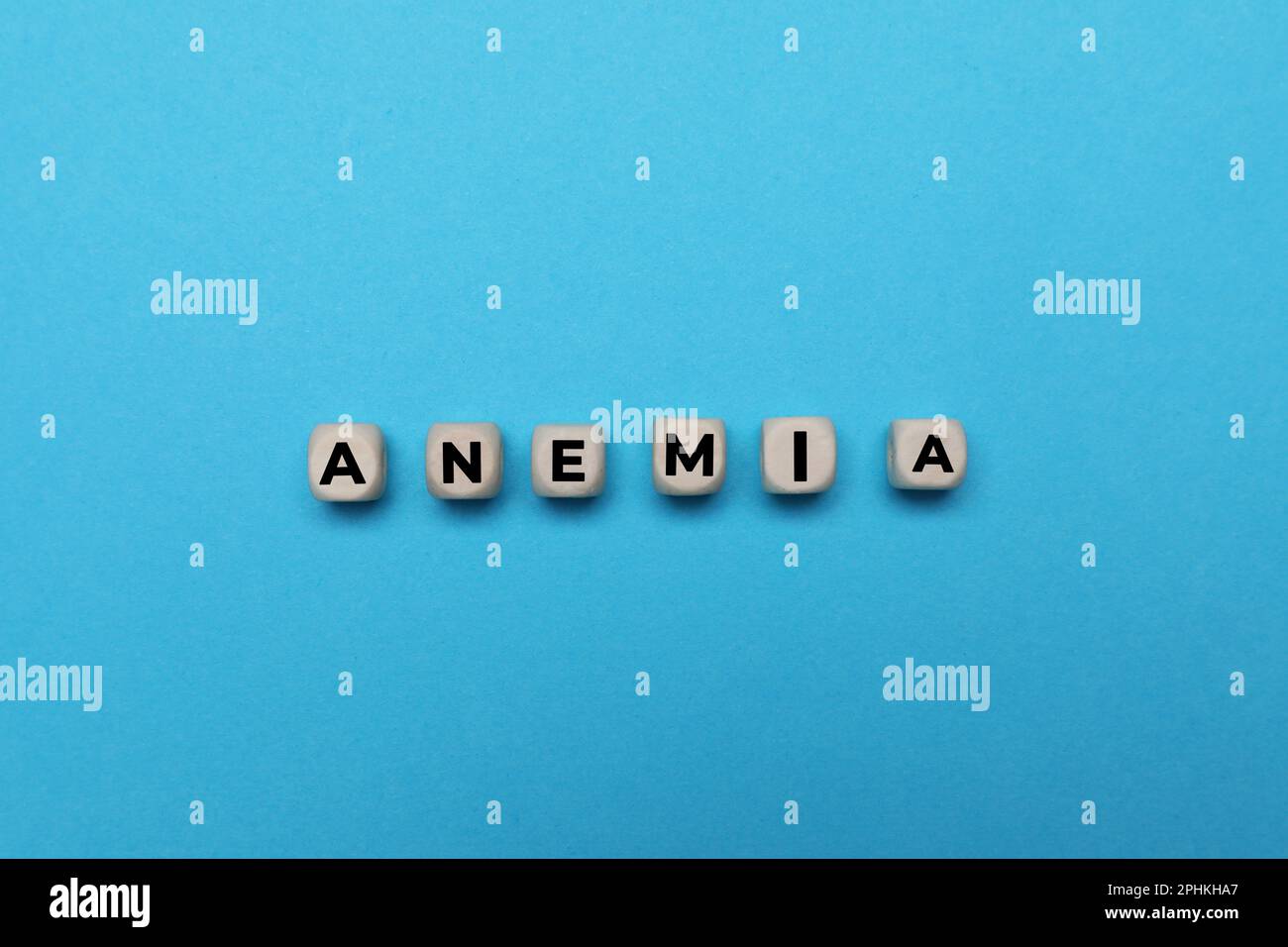 Word Anemia made of small wooden cubes on light blue background, flat ...