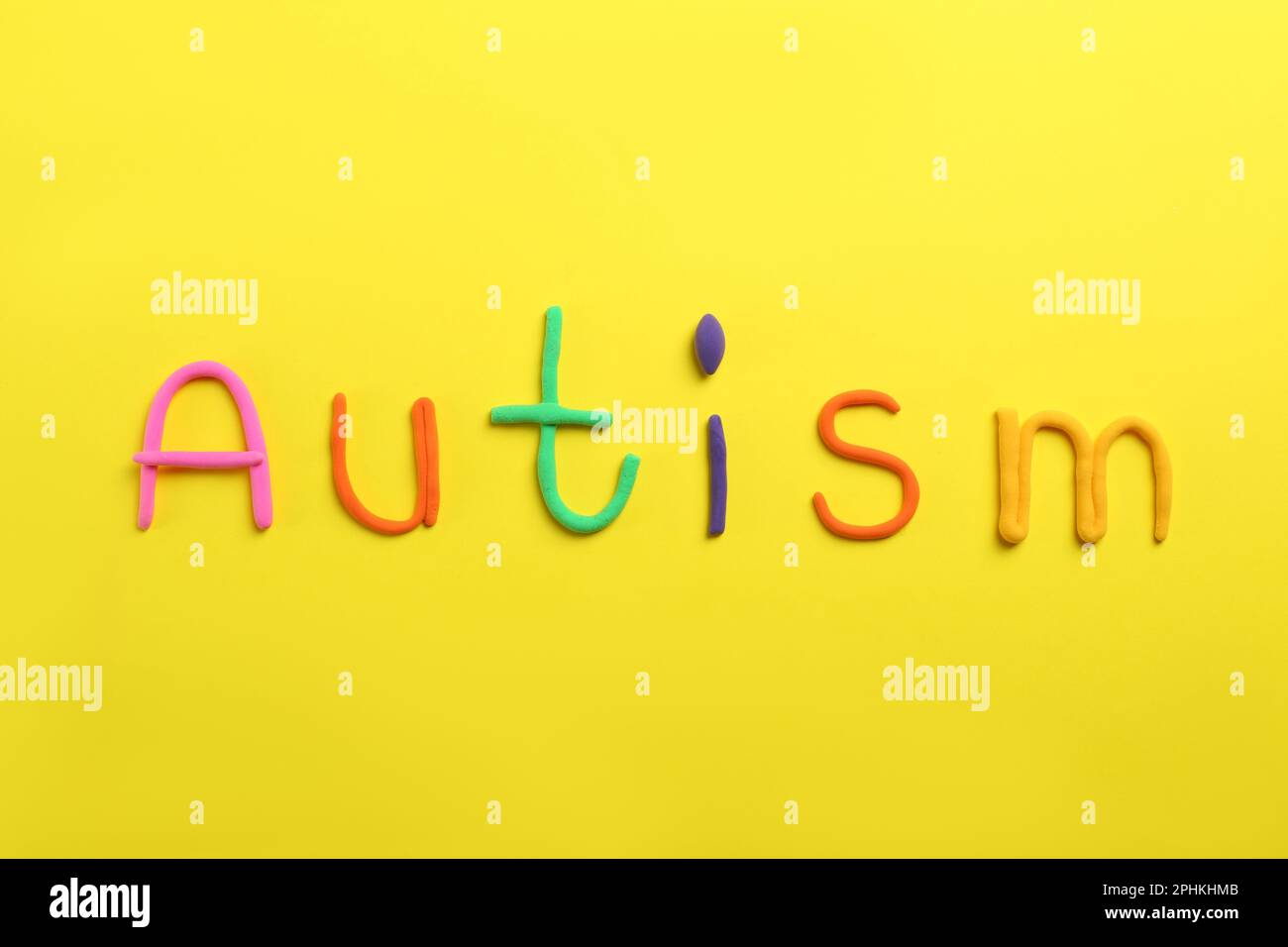 Word Autism made with colorful plasticine on yellow background, flat ...