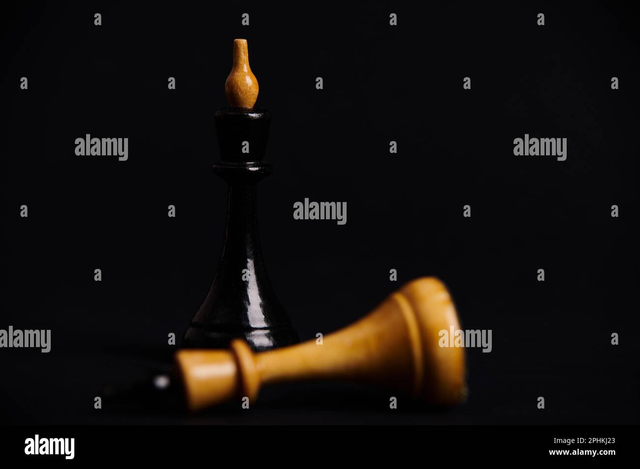 Focus on a black king chess piece fighting a white king falling down on ...