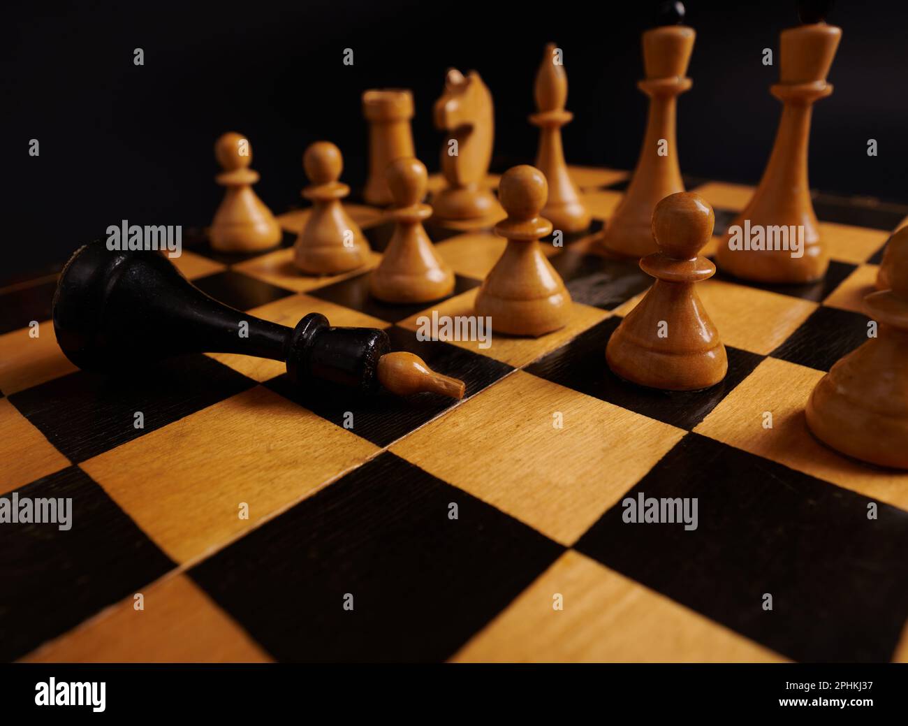 Black King chess piece falling down on chess battlefield in front of ...