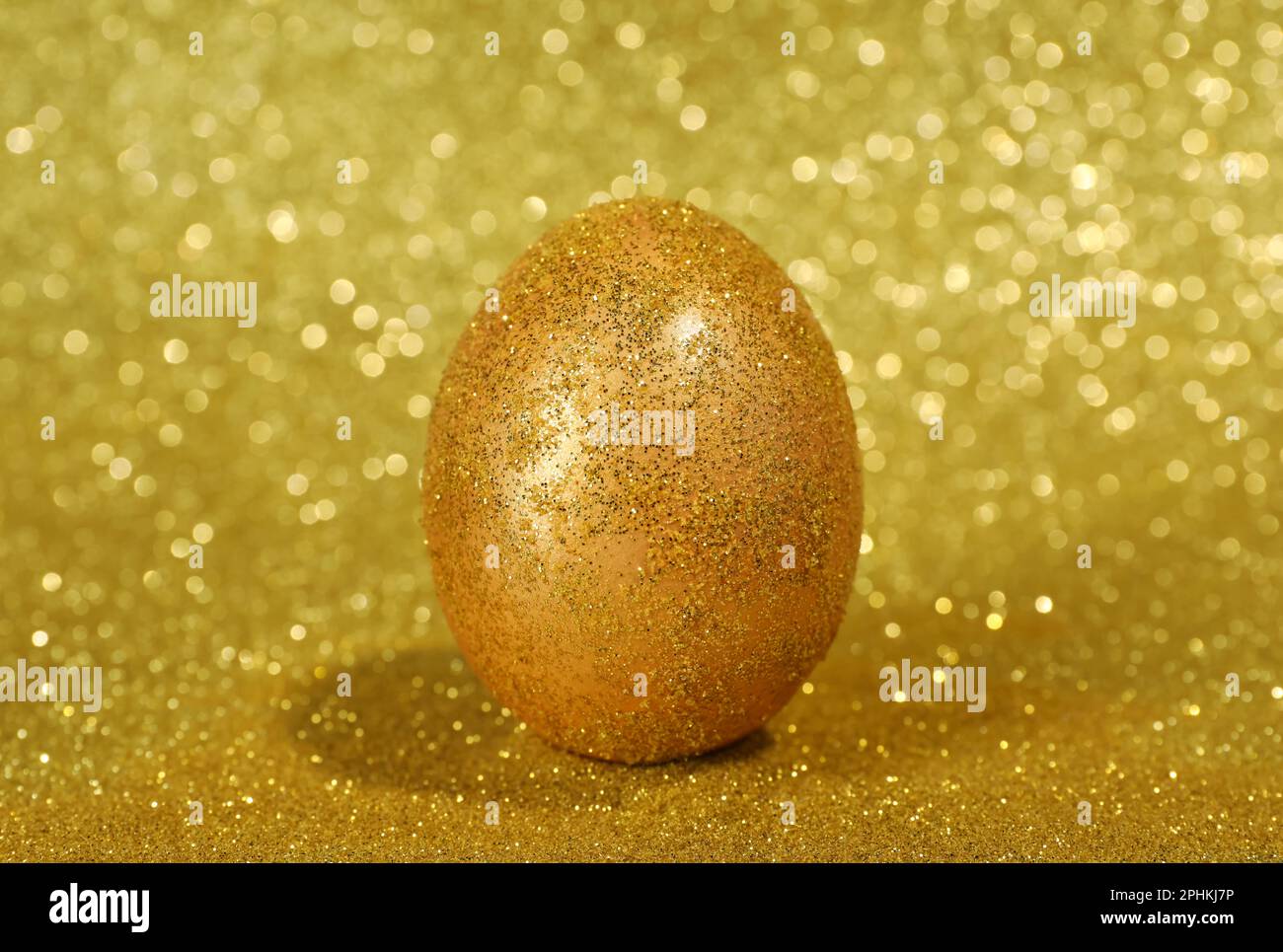 Shiny golden egg with glitter on yellow background, closeup Stock Photo ...