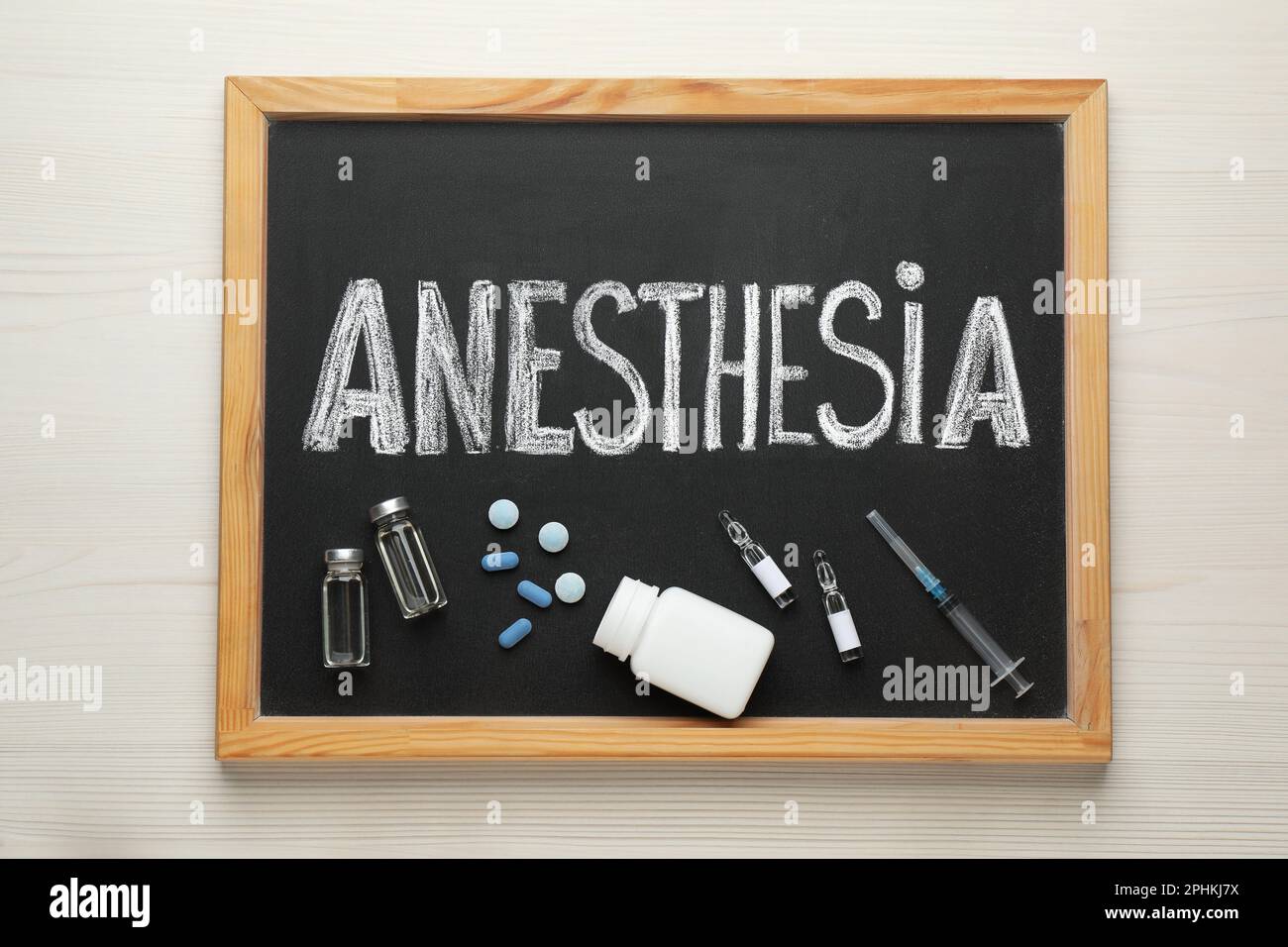 Blackboard with word Anesthesia, syringe and drugs on white wooden ...