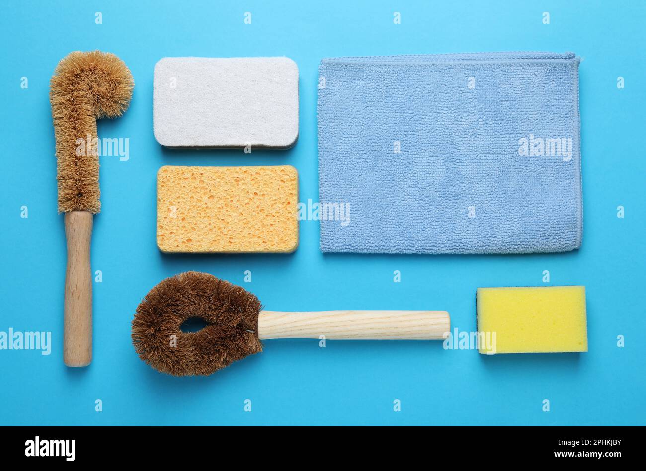 Many different sponges and other cleaning products on light blue ...