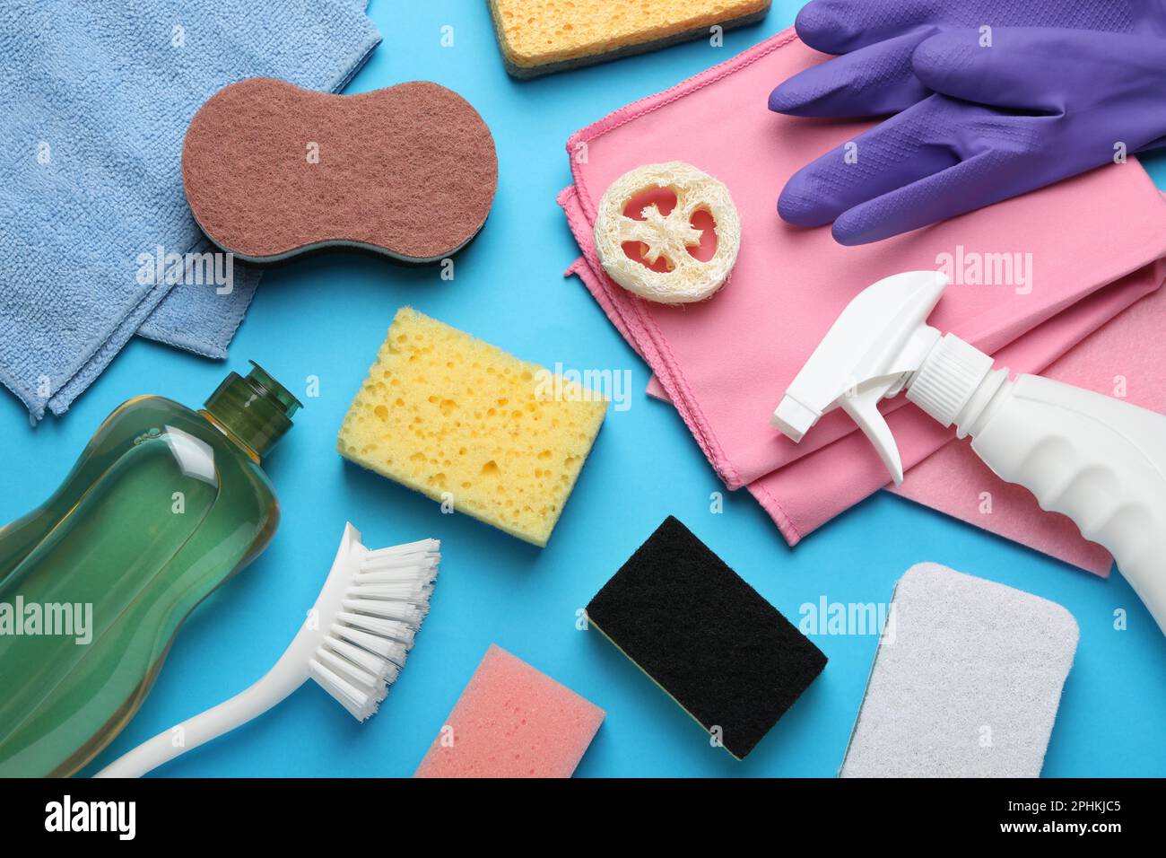 Many different sponges and other cleaning products on light blue ...