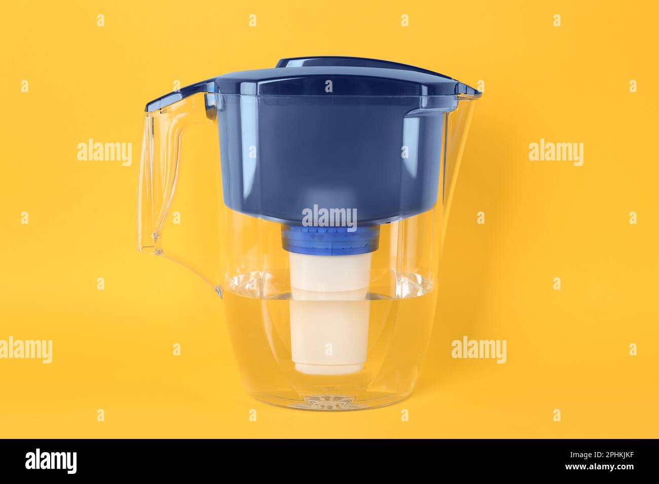 Filter jug with purified water on yellow background Stock Photo - Alamy