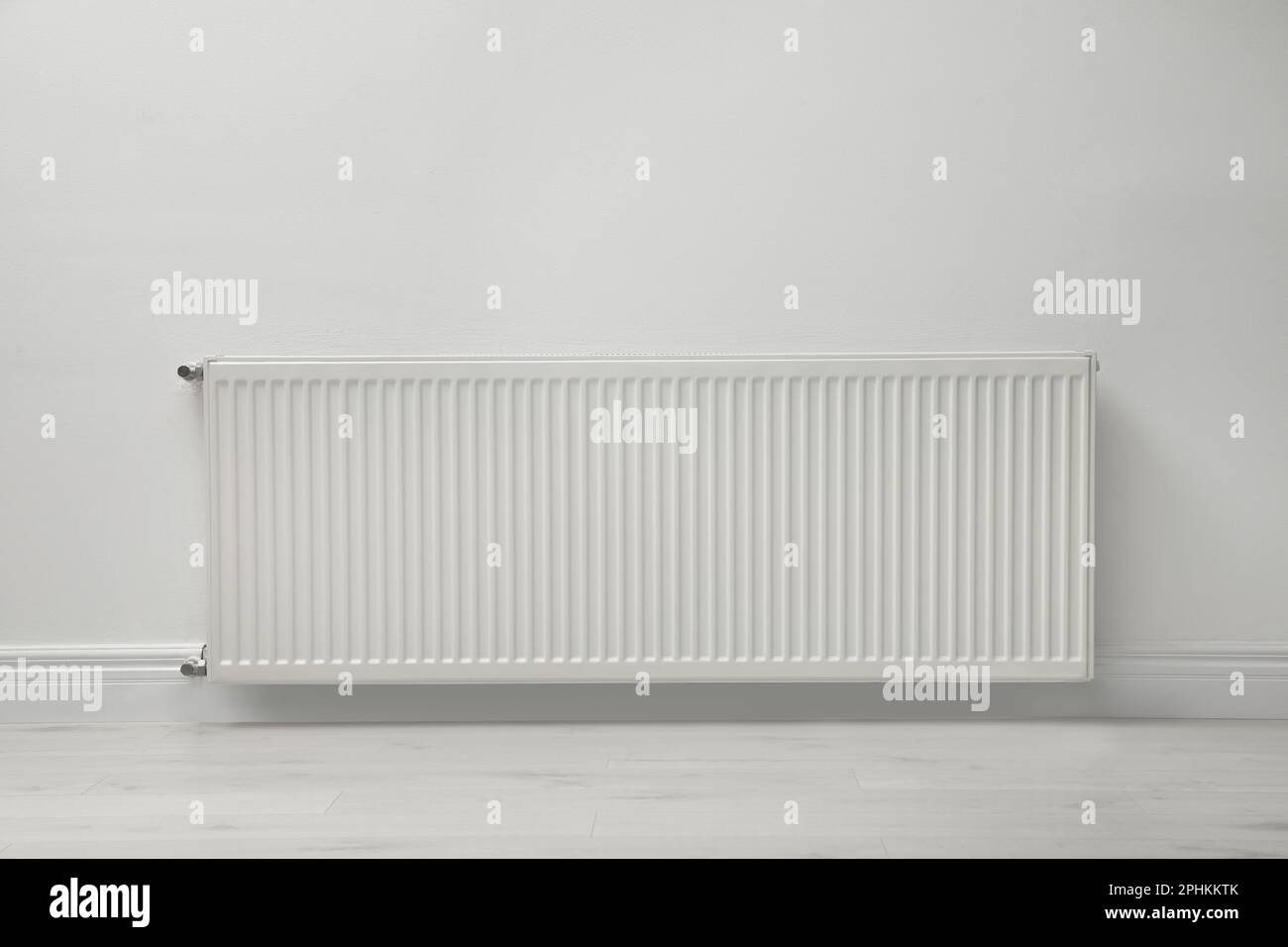 Modern radiator on white wall indoors. Central heating system Stock ...