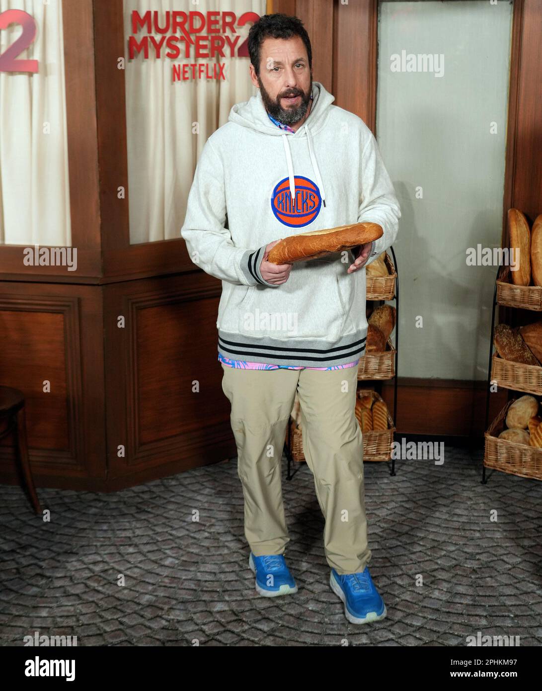 Los Angeles, USA. 28th Mar, 2023. Adam Sandler hands a loaf of bread to ...